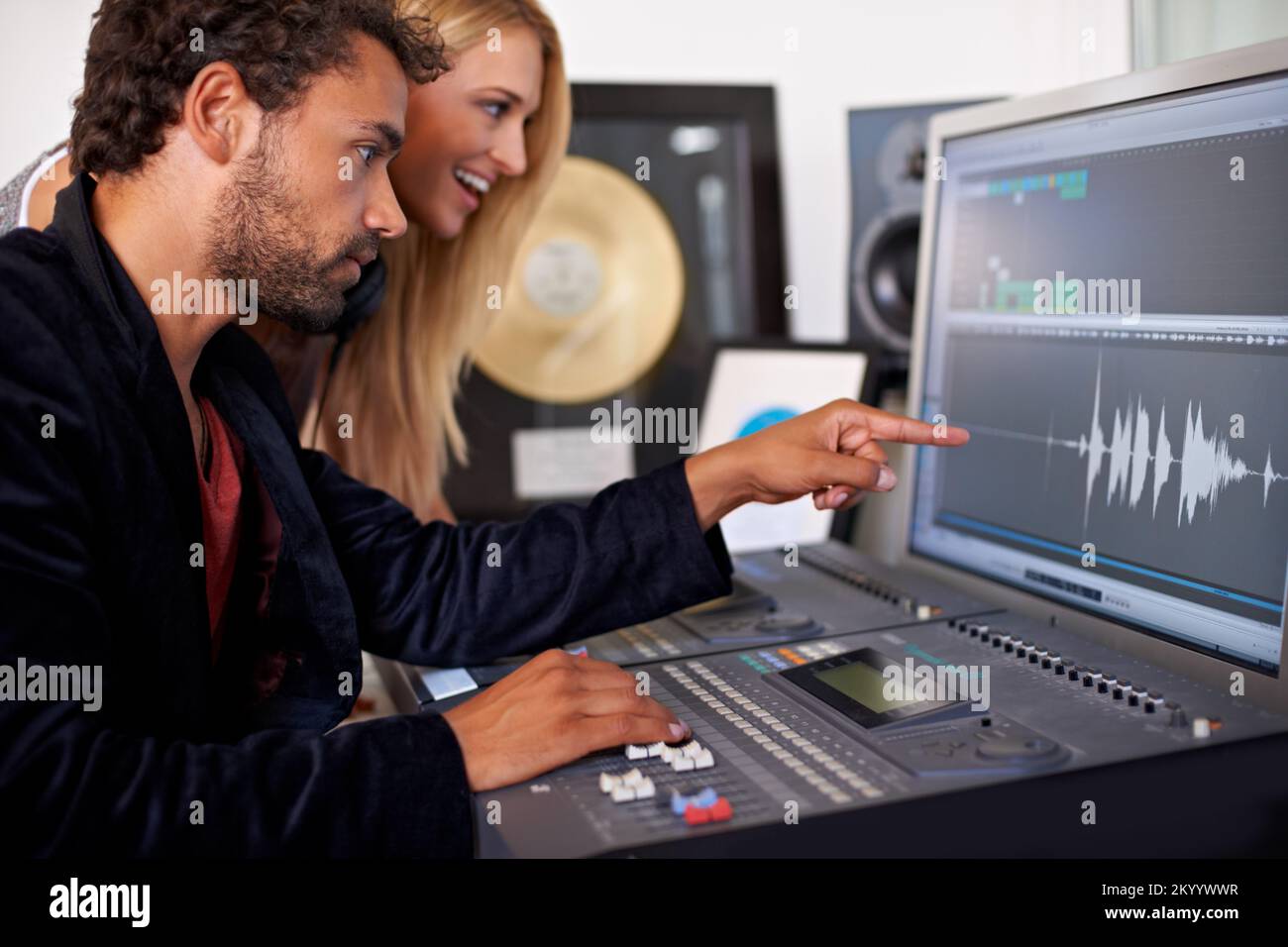 Seeing sound...A young audio engineer pointing at a visual ... Seeing sound...A young audio engineer pointing at a visual ...