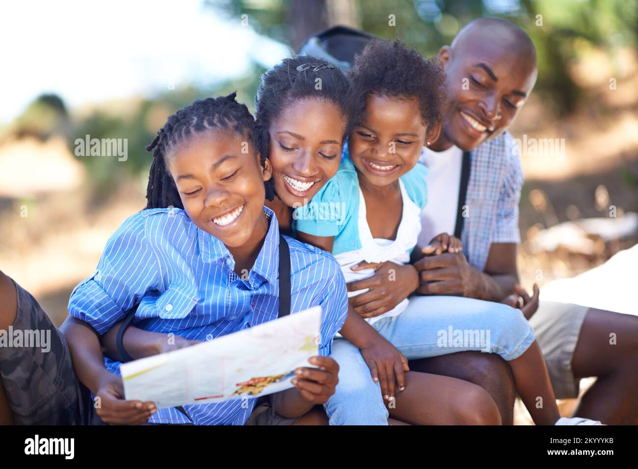 Getting lost is really fun. a happy-looking family looking at a map ...