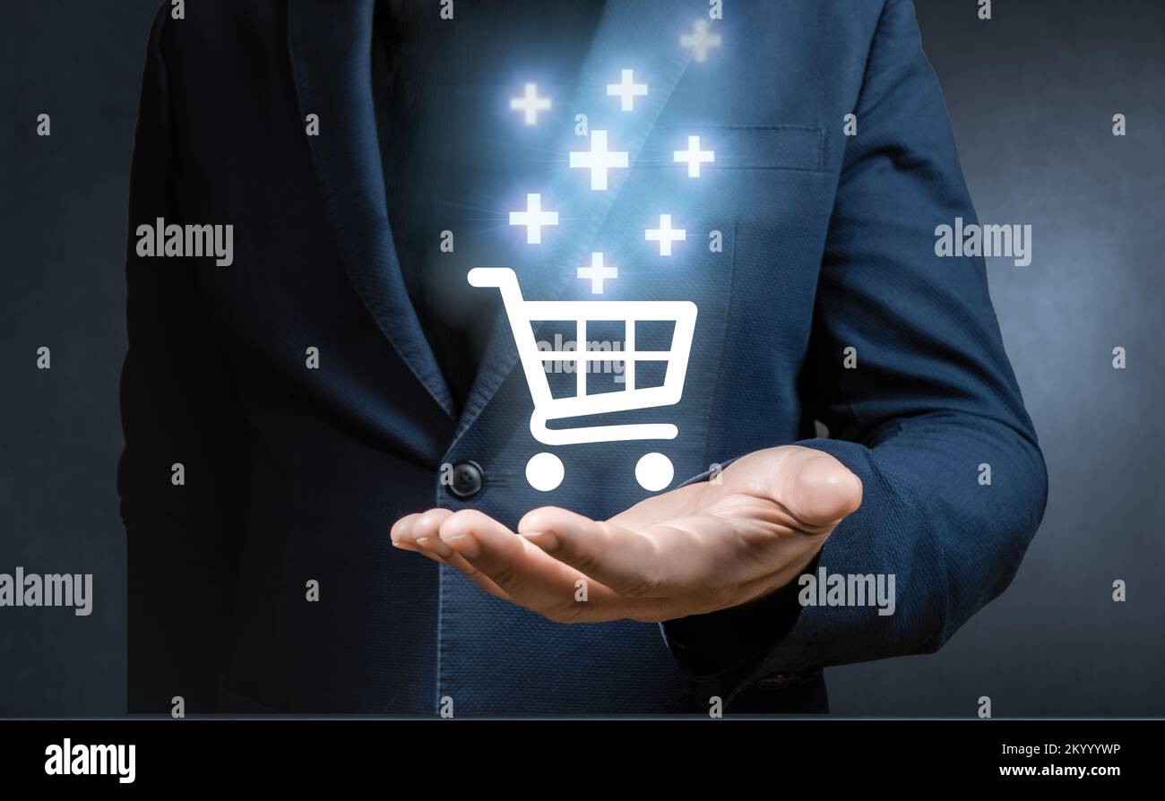 Sale volume increase. Businessman hand holding virtual trolley cart ...