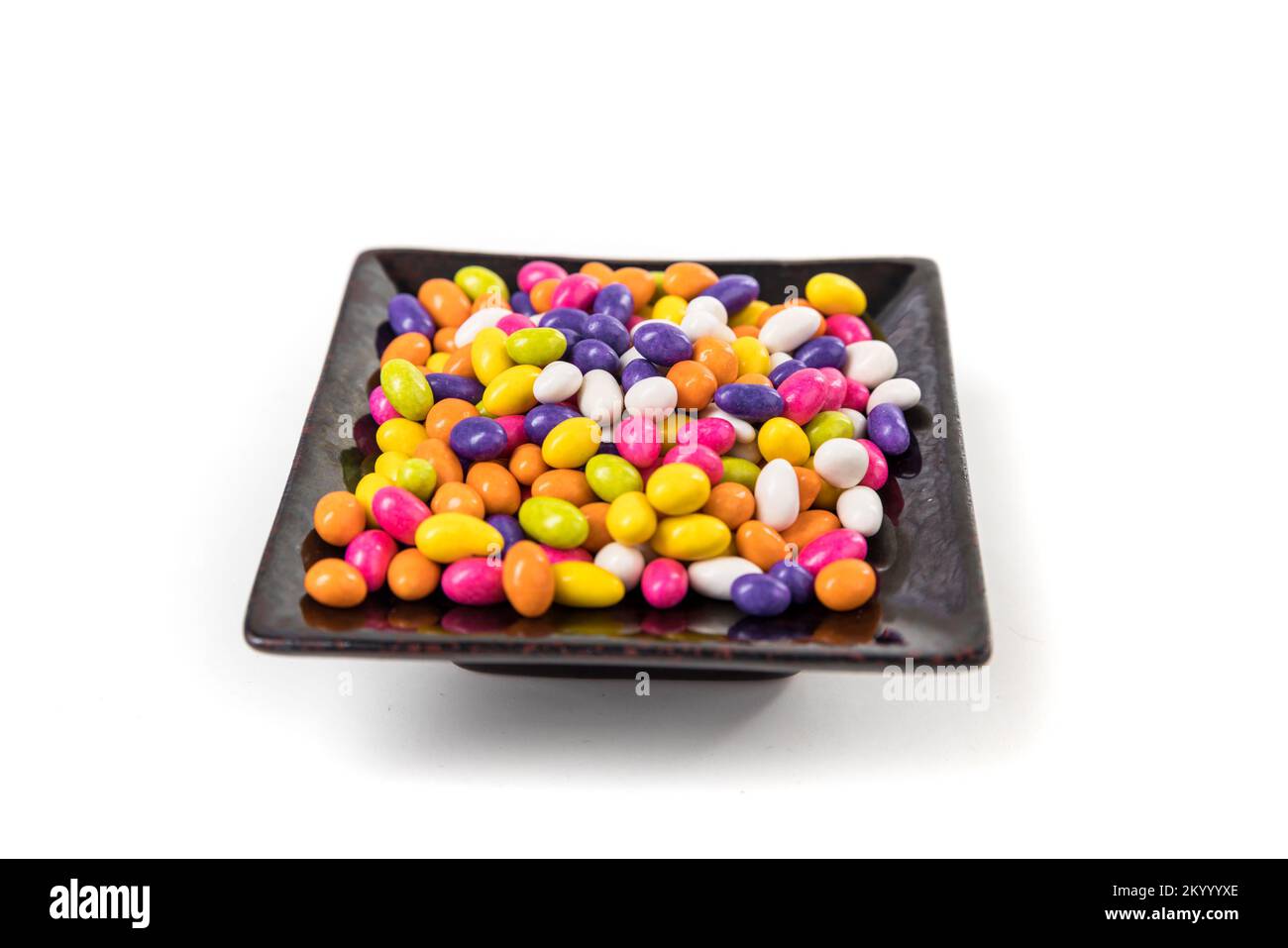 Multicolored fennel candy in a black tray isolated over white ...