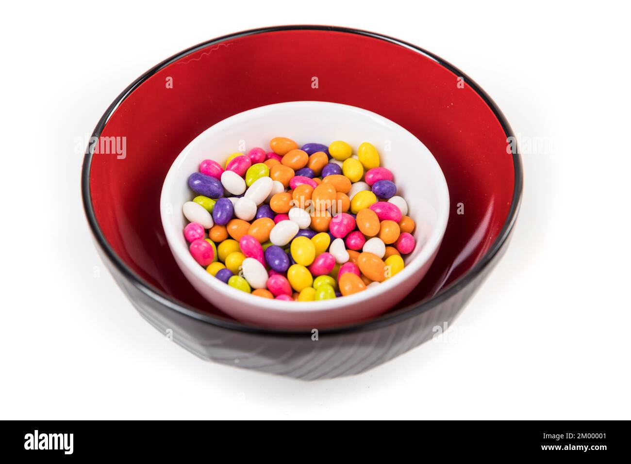 Fennel seed candy in a white red and black bowl isolated over white ...
