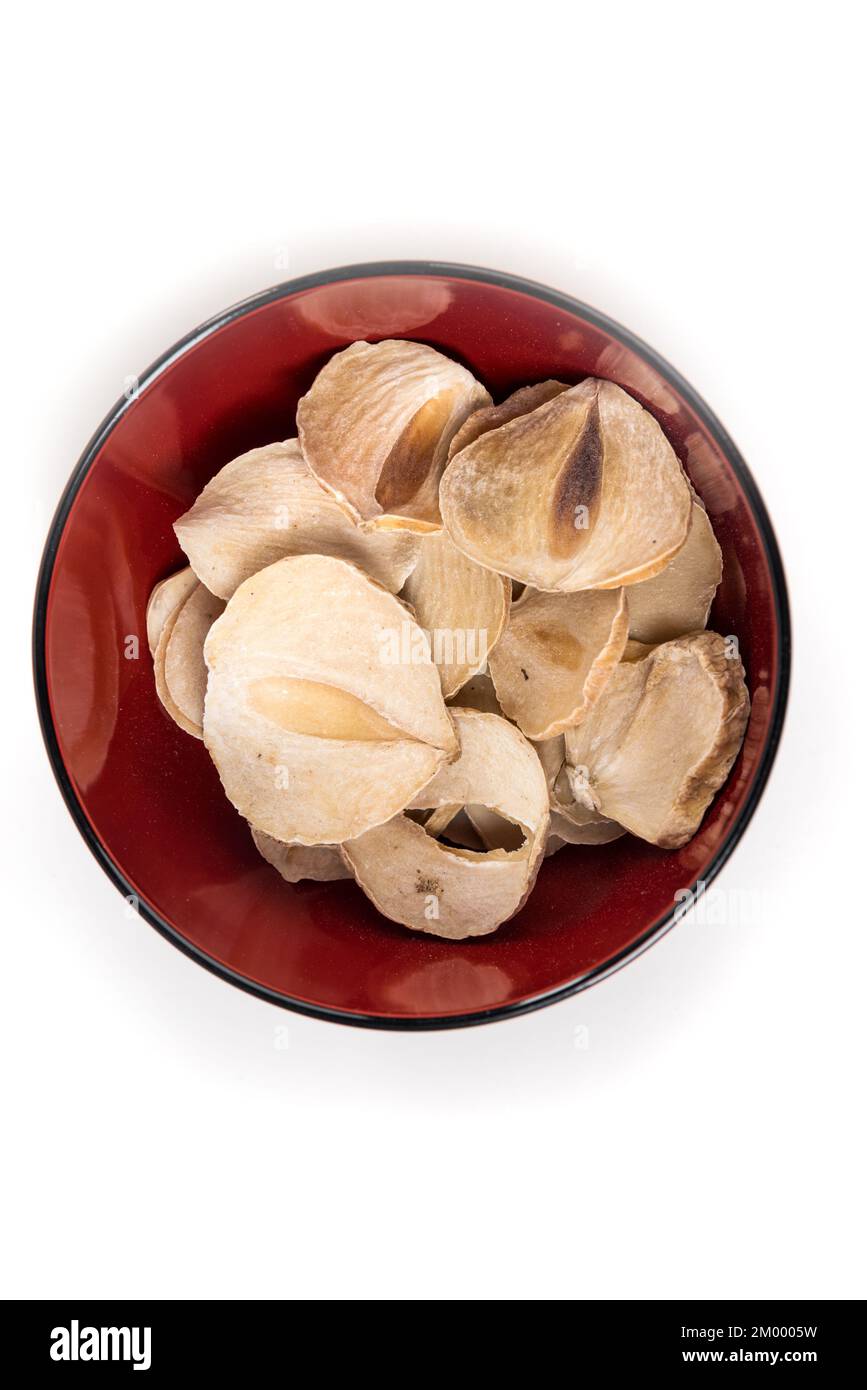 Sliced dried shallots in a red and black bowl top down isolated over ...