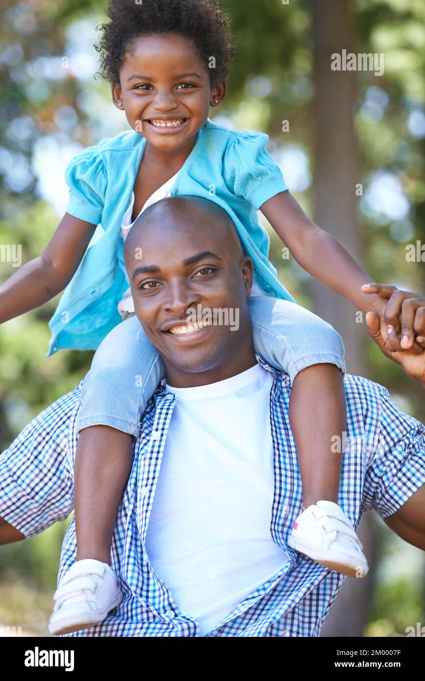Daddys girl loves nature. Portrait of a father carrying his daughter on his shoulders while ...