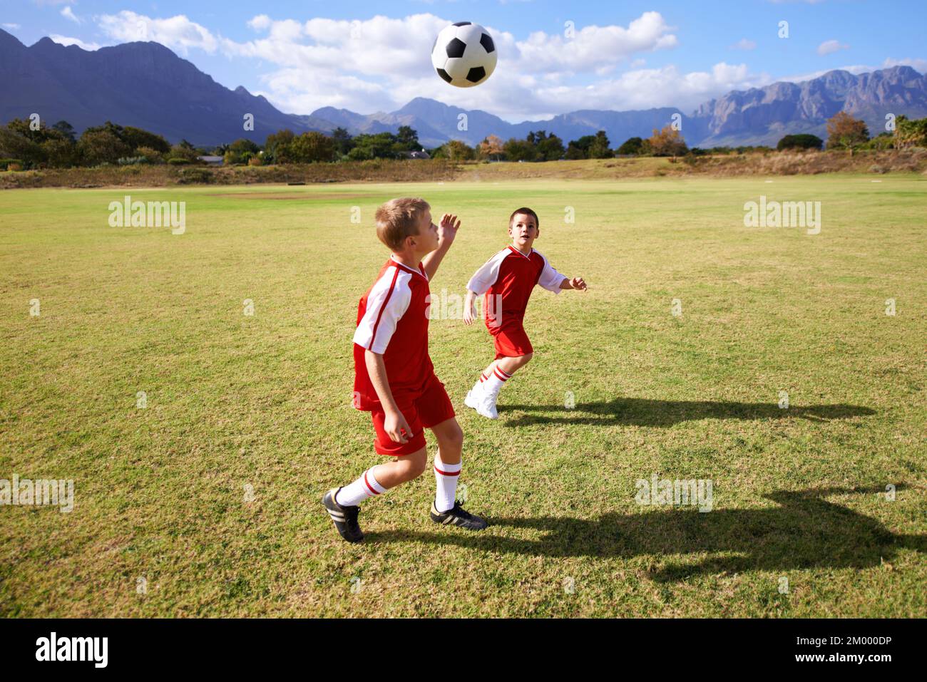 Learning teamwork while playing together. Two boys playing soccer on a ...