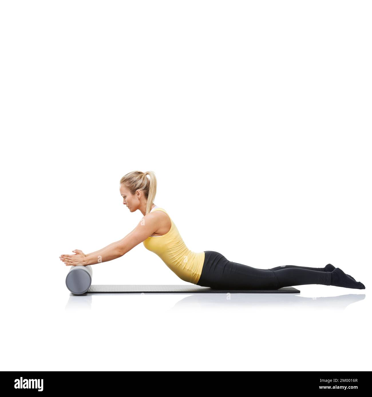 Stretching out her muscles with a foam roller. A young woman using a ...