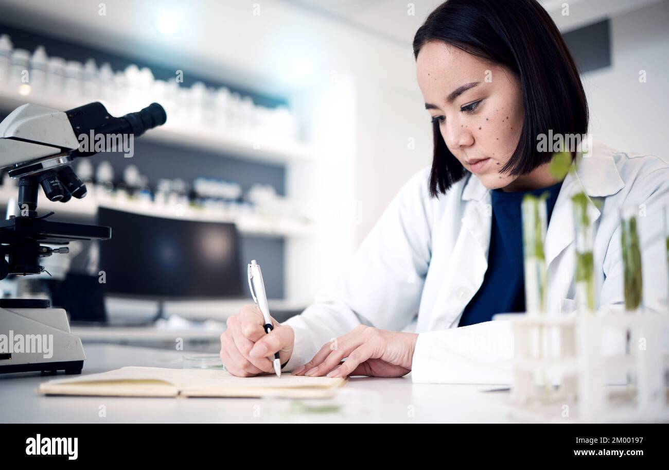 Scientist, woman and writing notes in laboratory, record test results ...