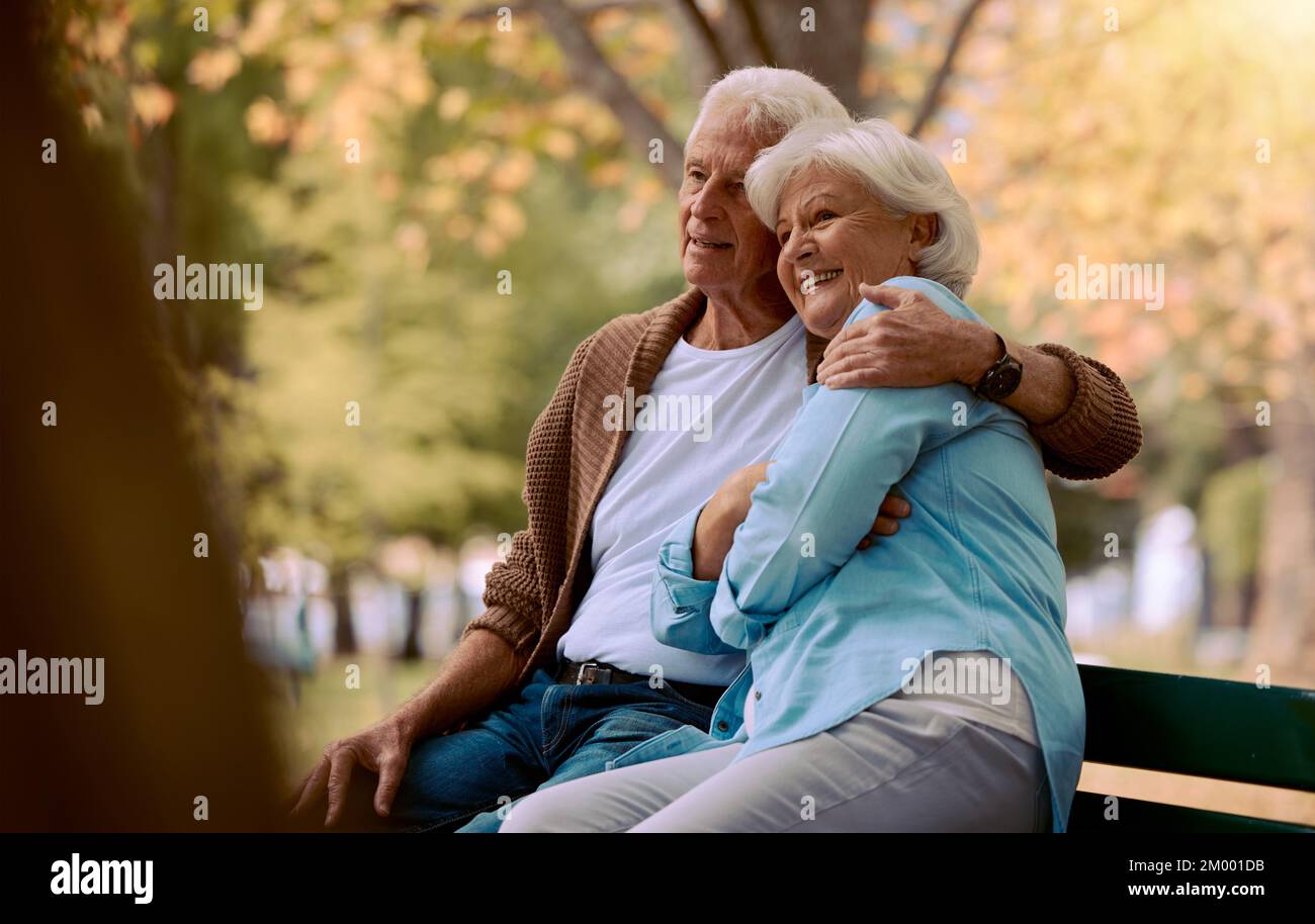 Couple, elderly and hug in park during retirement, sitting on park ...
