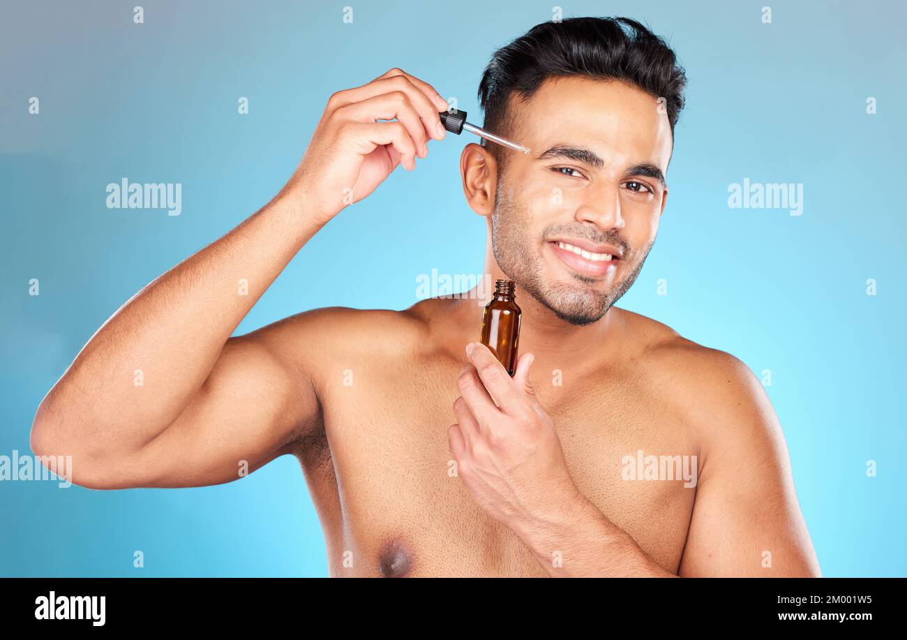 Man, face serum or skincare grooming on studio background for ...