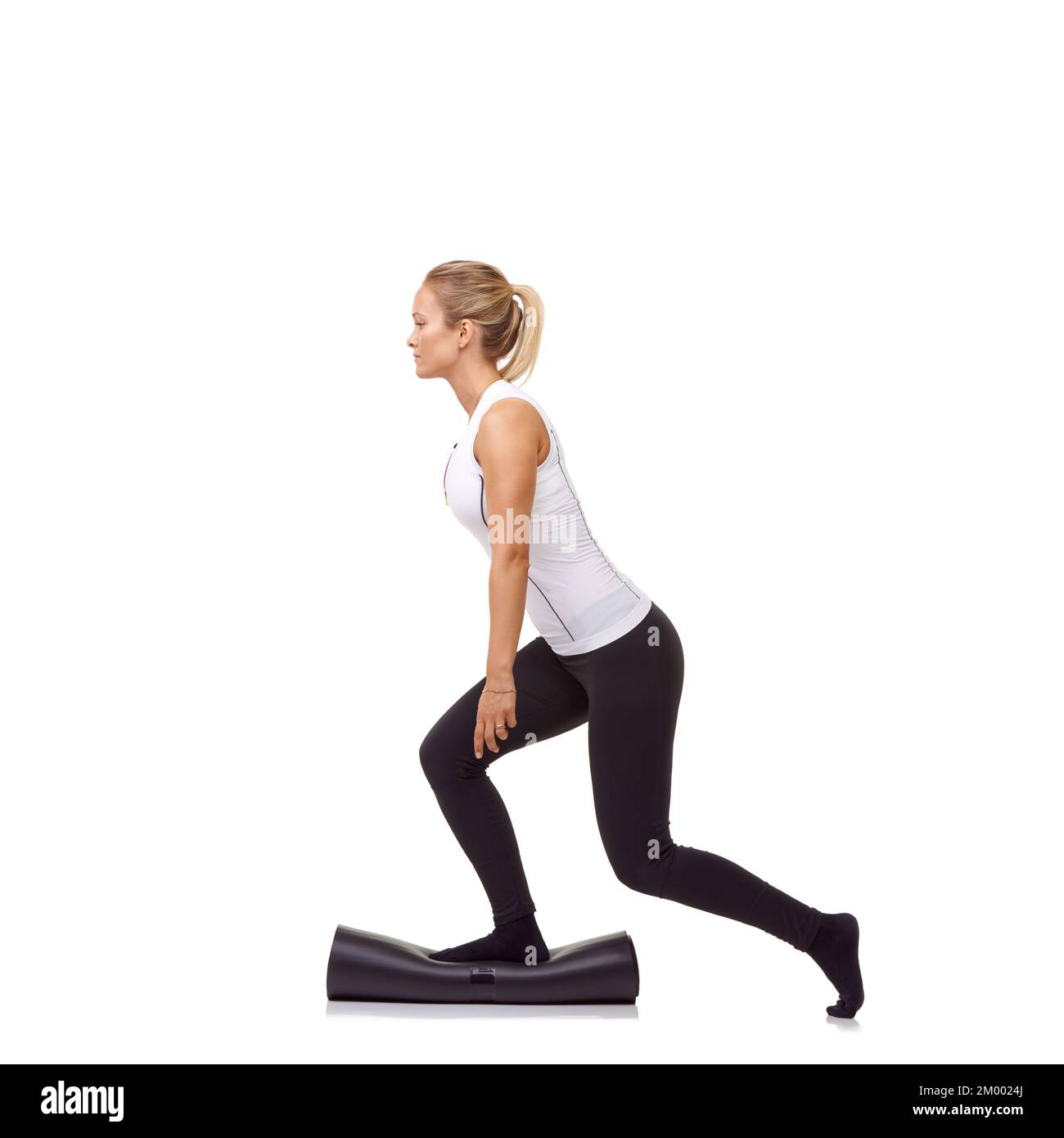 Lunging on her exercise mat. A pretty young woman balancing on her ...