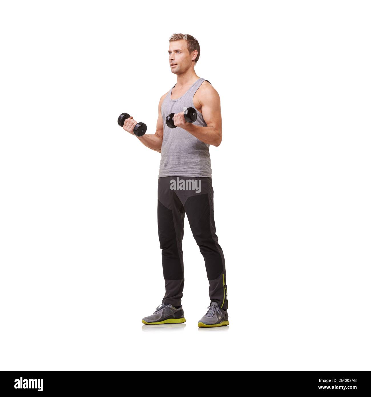 Toning his biceps. Full-body of a fit young man doing bicep curls while ...