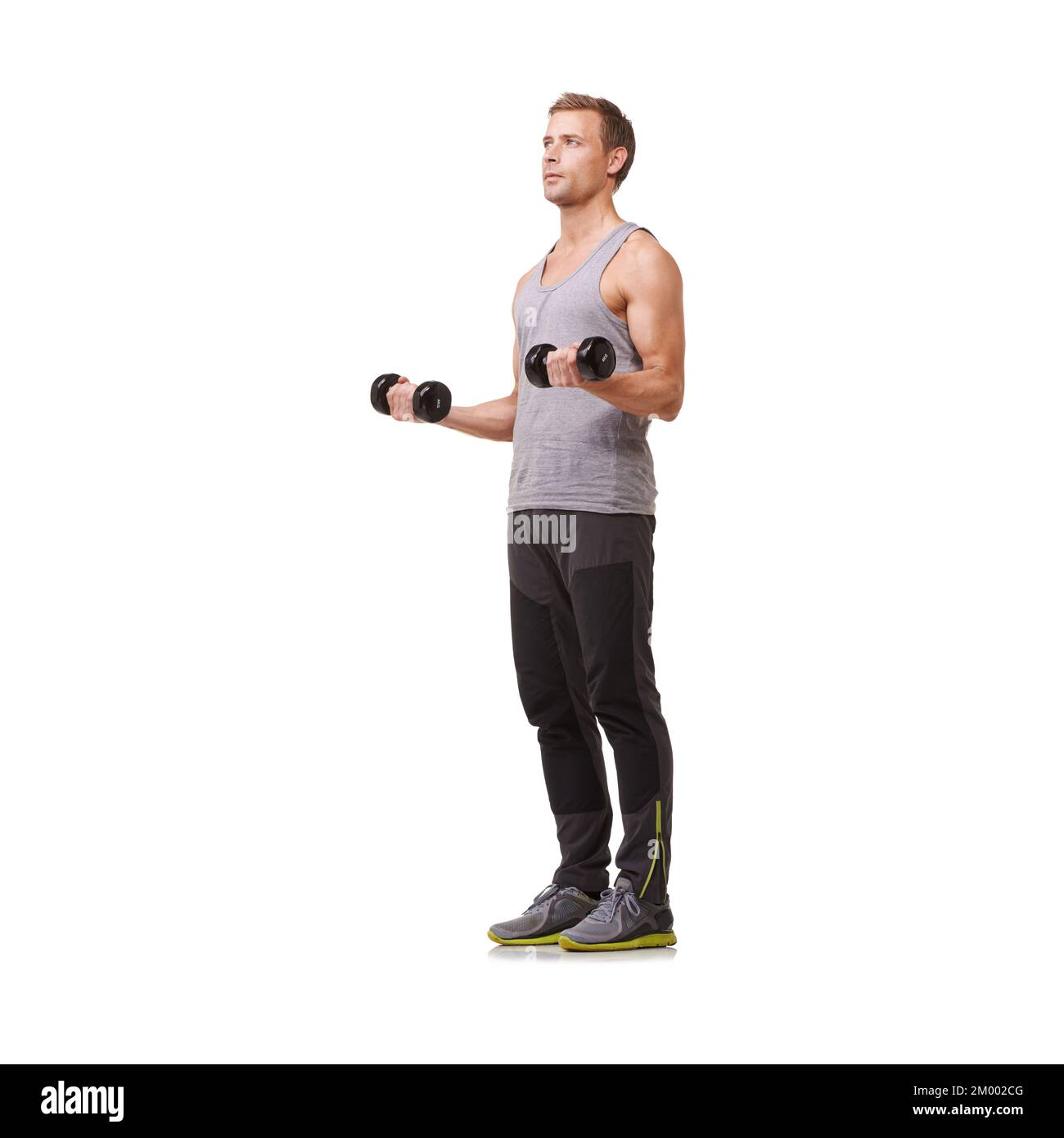 Feeling the burn. Full-body of a fit young man doing bicep curls while ...