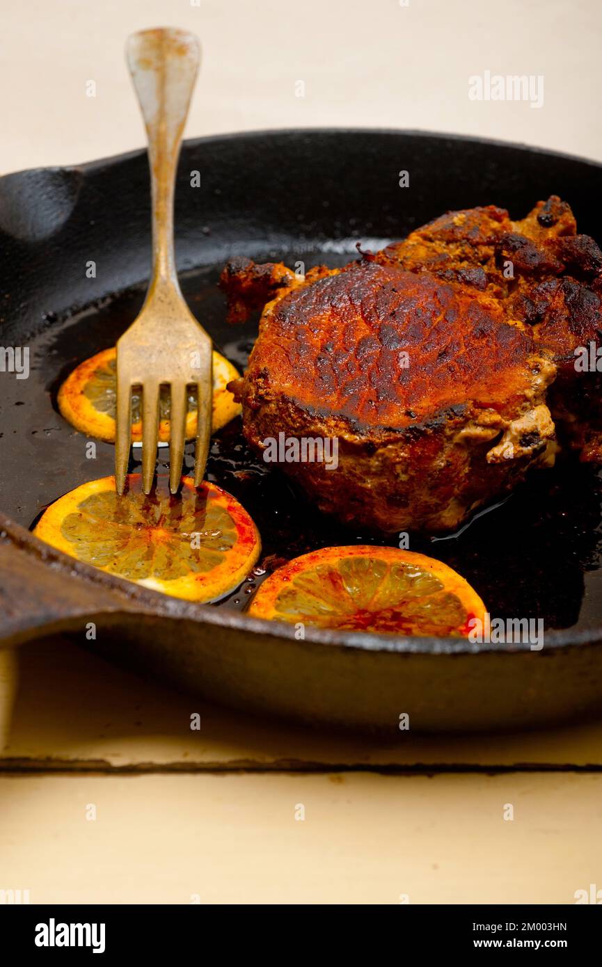 Pork chop seared on iron skillet with lemon and spices seasoning Stock ...