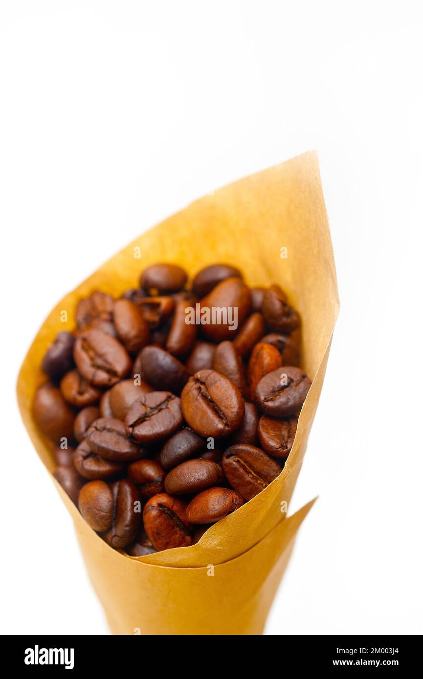 Espresso coffee beans on a paper cone cornucopia over white background ...