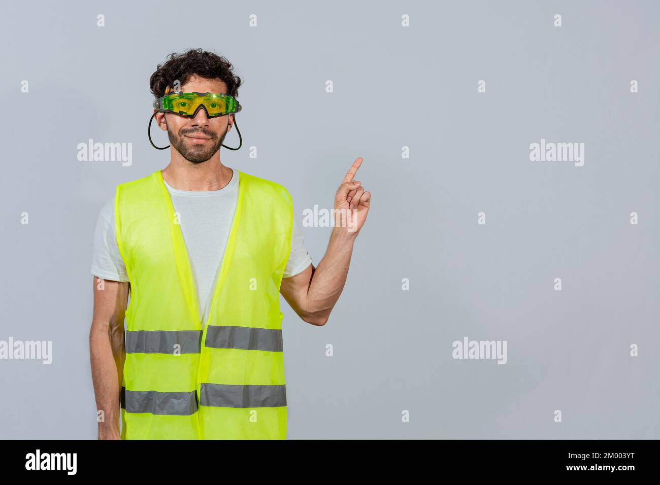 Construction worker with vest surprised pointing an advertisement to ...