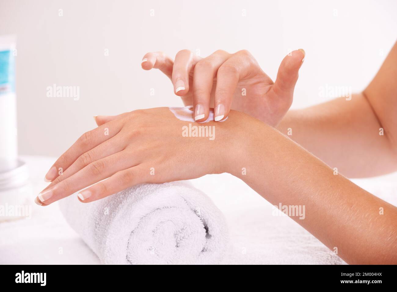 Keeping her hands silky and soft. a woman applying lotion to her hands ...