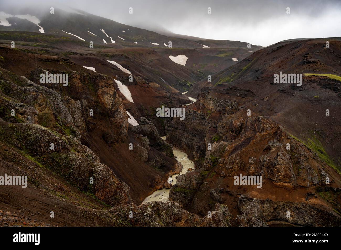 River in a gorge, foot of Asgardsa, volcanic landscape with black and ...