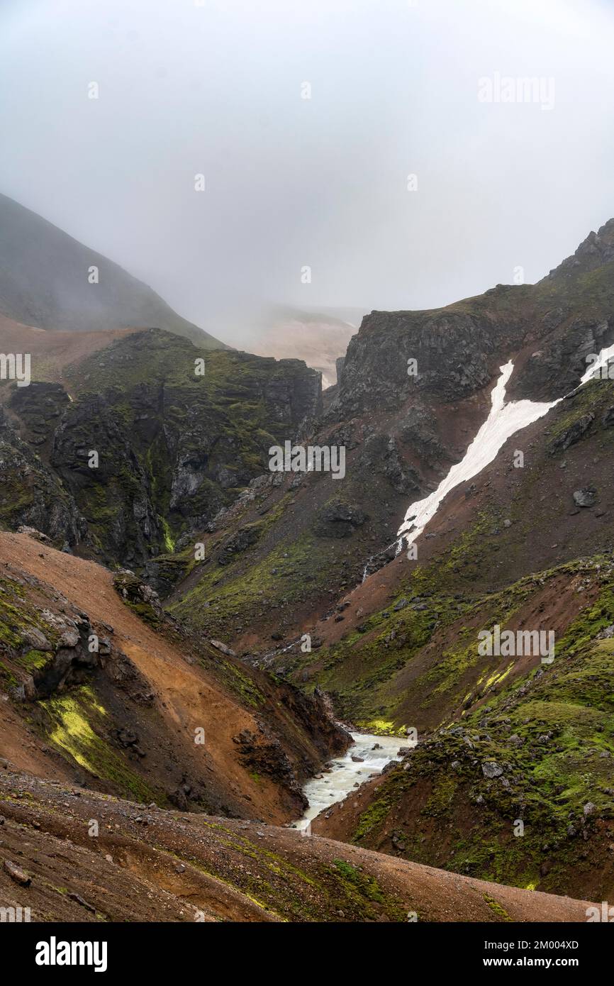 River in a gorge, foot of Asgardsa, volcanic landscape with black and ...