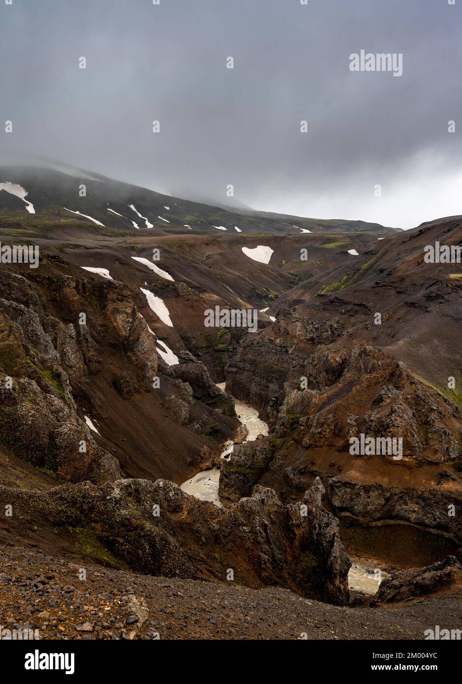 River in a gorge, foot of Asgardsa, volcanic landscape with black and ...