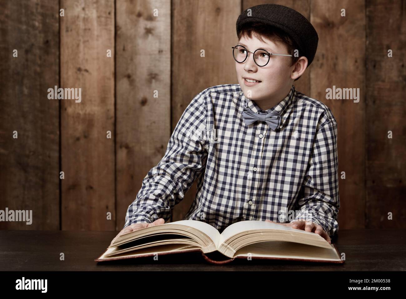 Thinking over what hes read. Young boy in retro clothing wearing ...