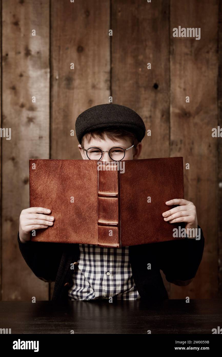 Hiding his knowledge. Young boy in retro clothing wearing spectacles ...
