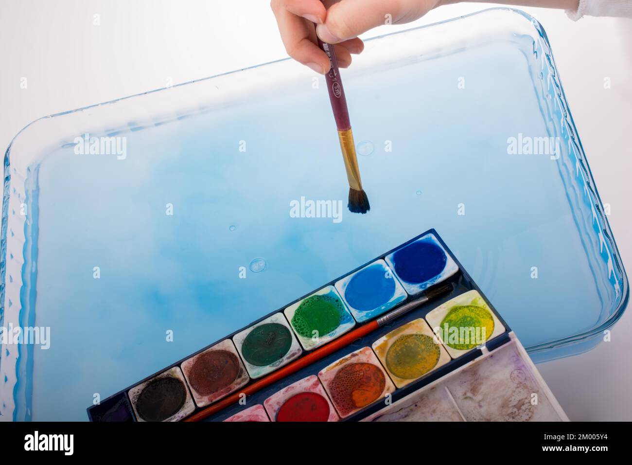 Paint dissolving in water as painting brush touching water Stock Photo ...