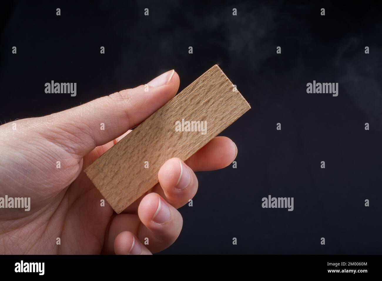Small piece of cut wood in hand background Stock Photo - Alamy