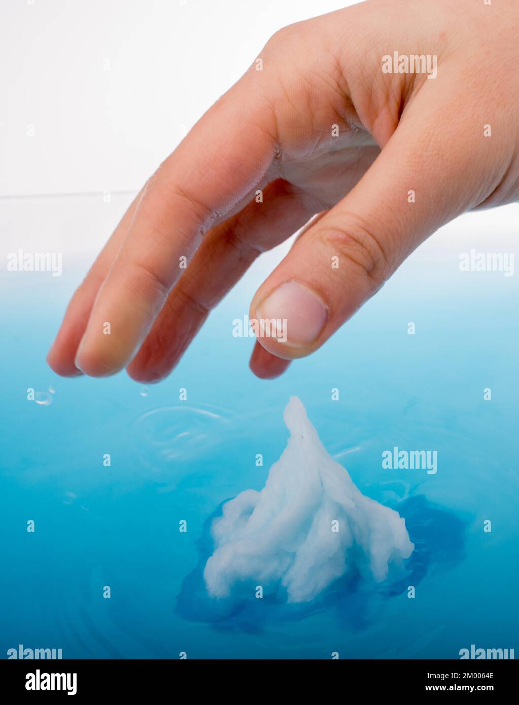 Hand holding some cotton in blue water Stock Photo - Alamy