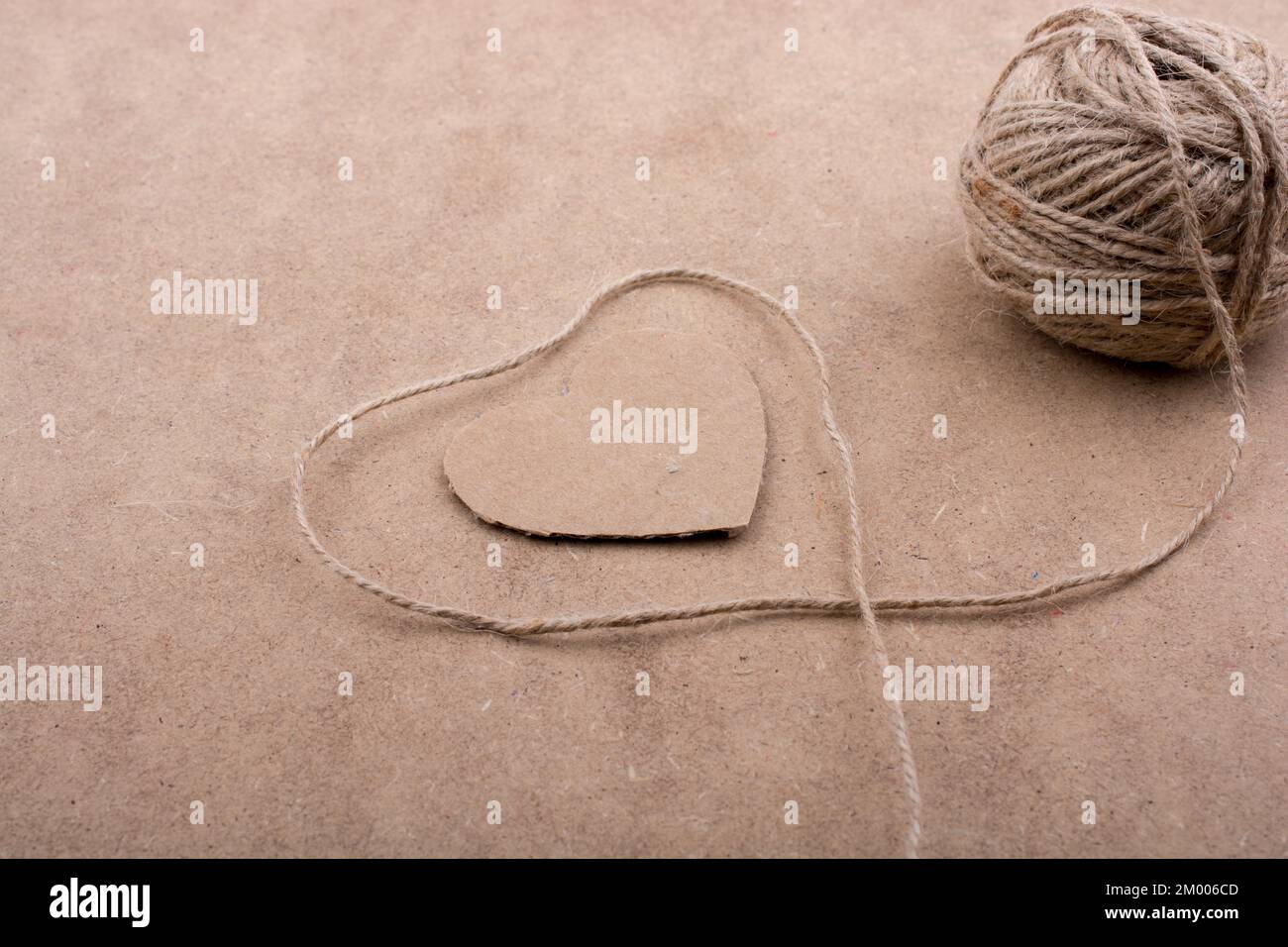 Thread off spool form a heart shape on brown background Stock Photo - Alamy