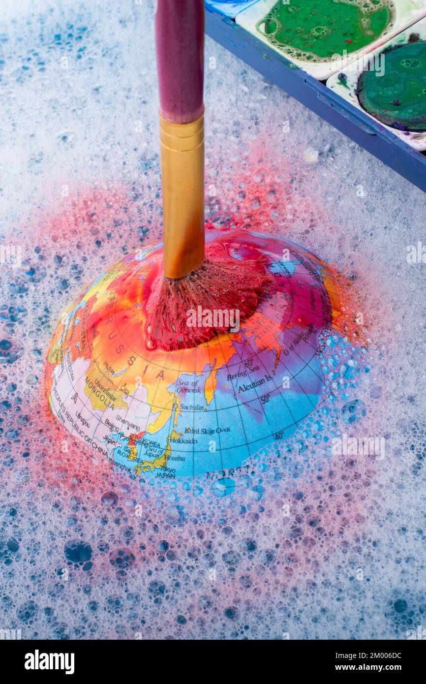 Paint dissolving through painting brush on the top of globe Stock Photo ...