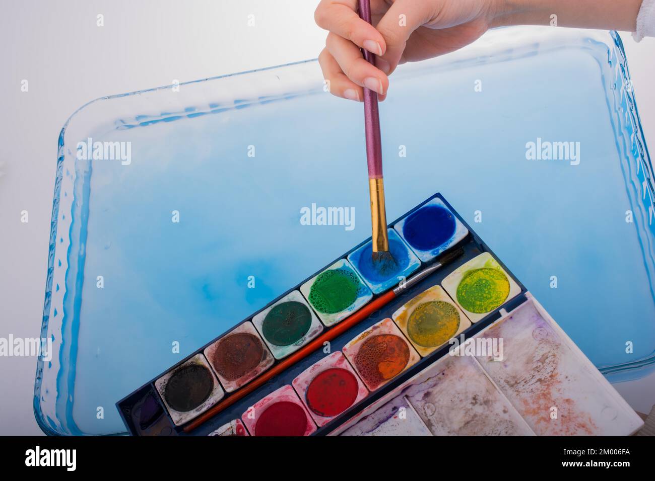 Paint dissolving in water as painting brush touching water Stock Photo ...
