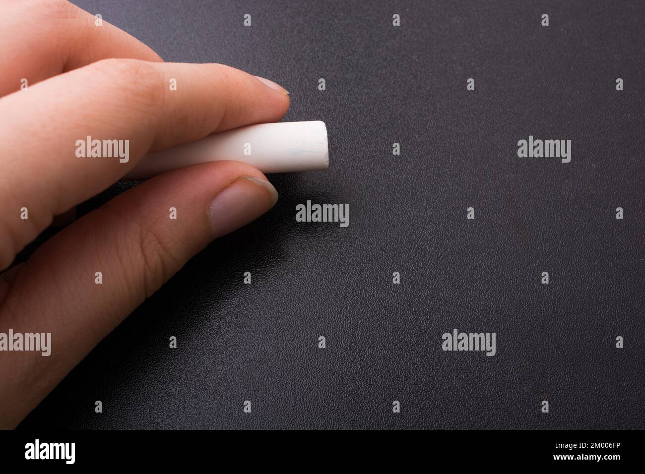 Hand holding white chalk and black board Stock Photo - Alamy