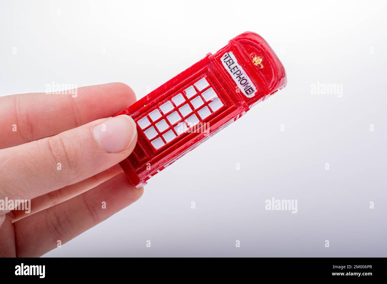 Hand holding a red color phone booth on a white background Stock Photo ...