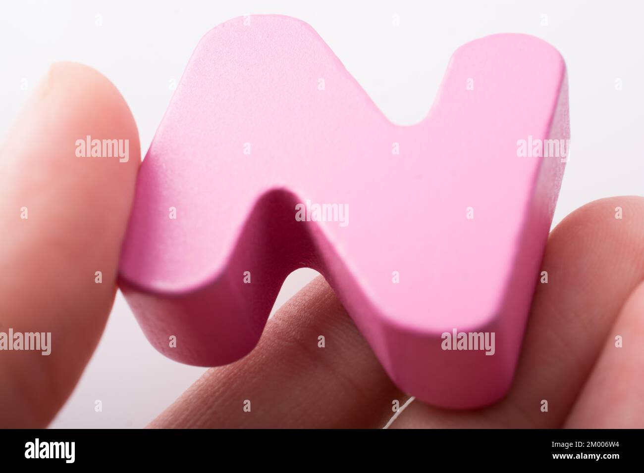 Hand holding letter cube N of made of wood Stock Photo - Alamy