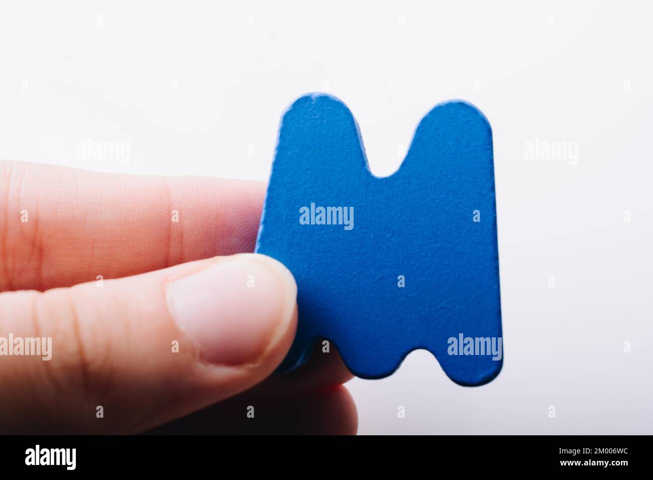 Hand holding letter cube M of made of wood Stock Photo - Alamy