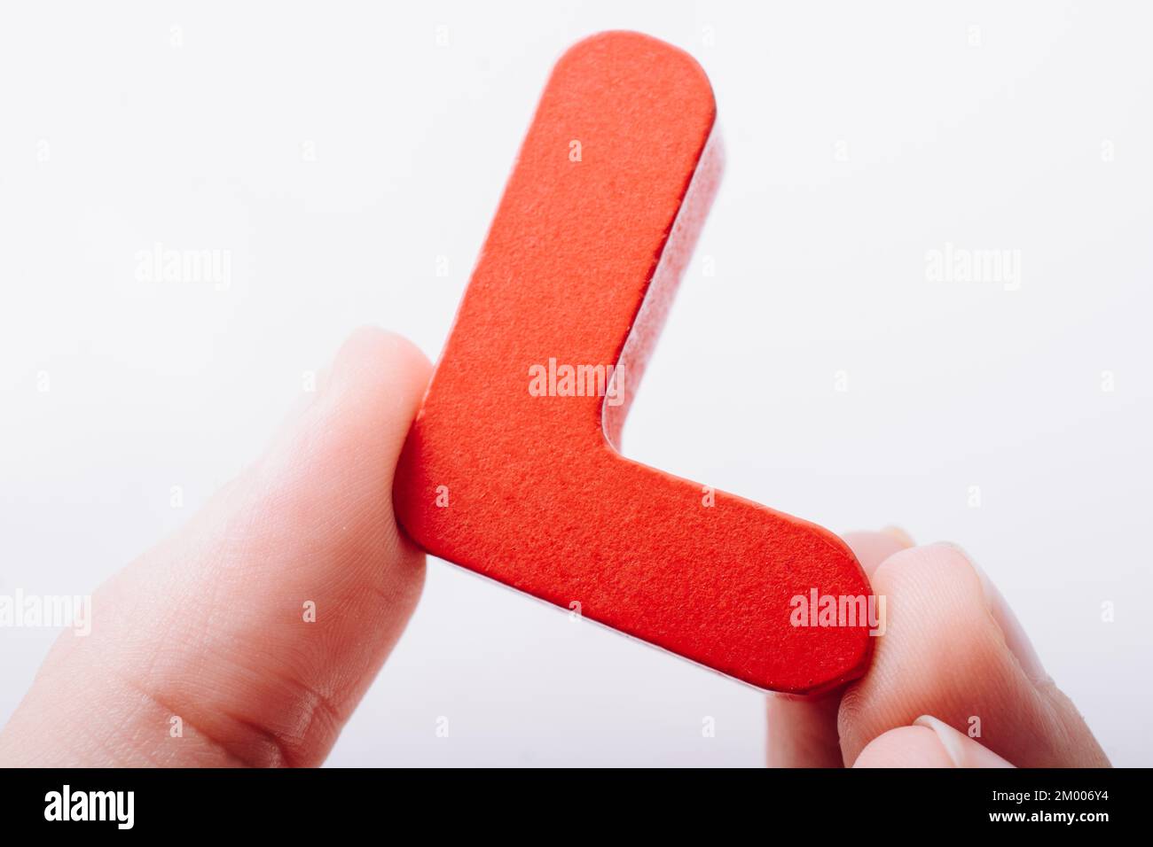 Hand holding letter cube L of made of wood Stock Photo - Alamy