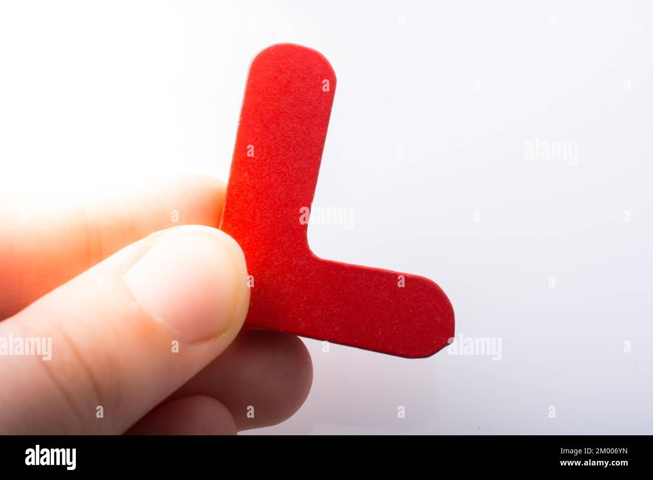 Hand holding letter cube L of made of wood Stock Photo - Alamy