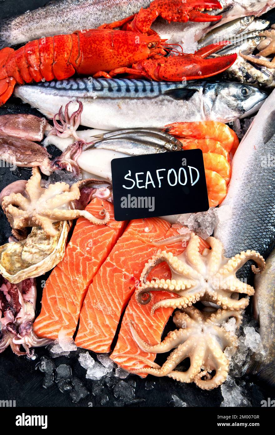 Fresh fish and seafood assortment on black background, fish market ...
