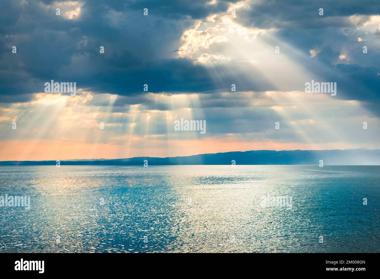 Tyndall effect over Lake Constance, sun rays break through cloudy sky ...