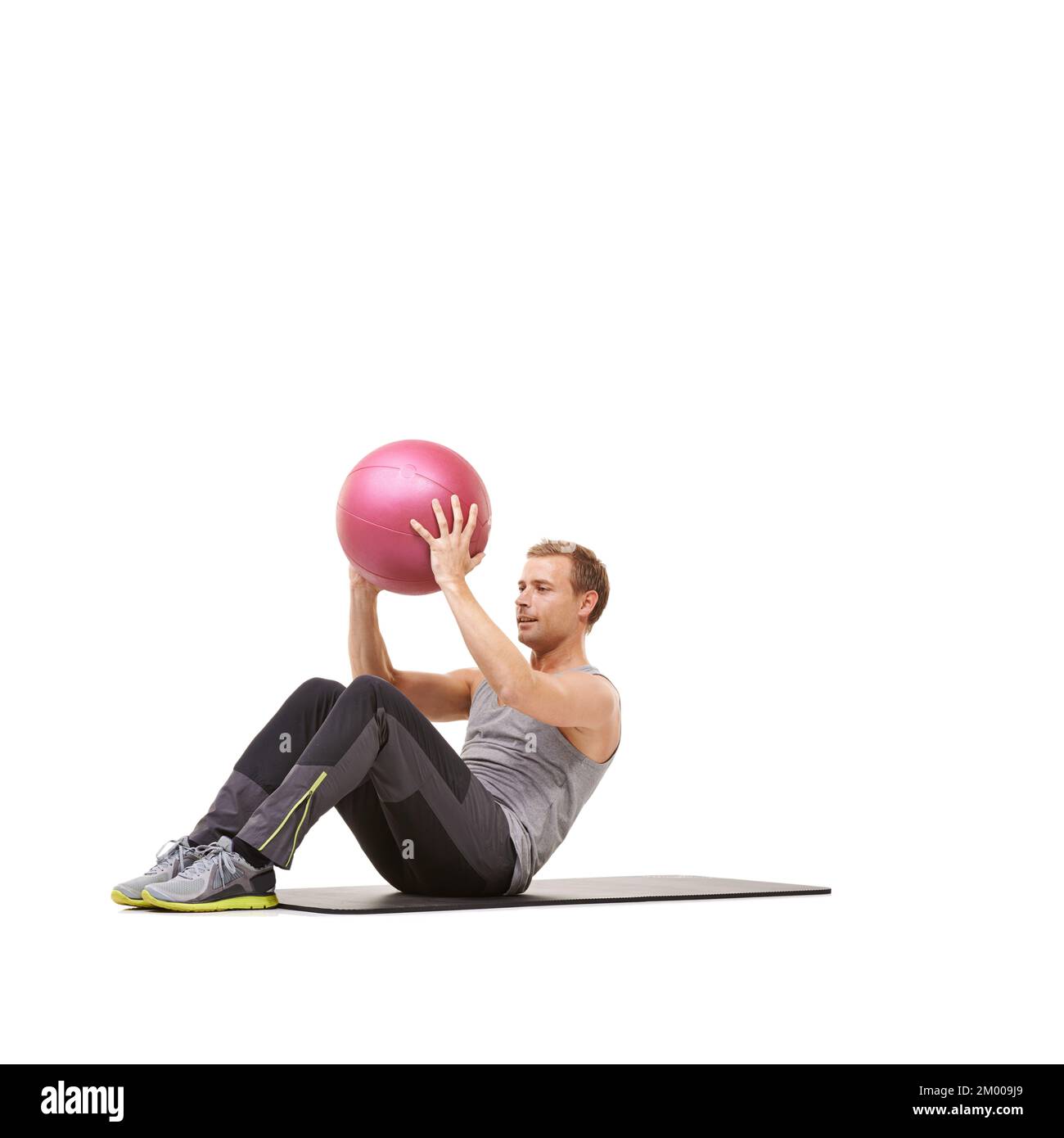 Fitness fanatic. A young man working out with a medicine ball on a ...