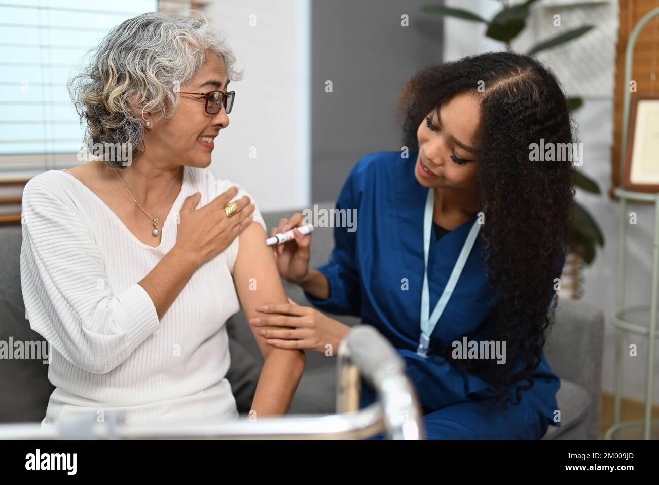 Doctor injecting diabetes treatment into upper arm of diabetic senior ...