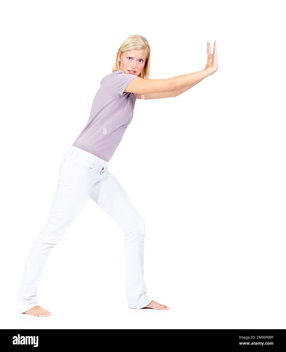 This wont budge. Pretty young woman pushing a object to the right ...