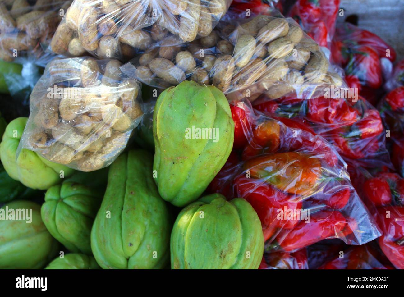 Caribbean cho-cho or christophine, peanuts and chilli peppers on a ...