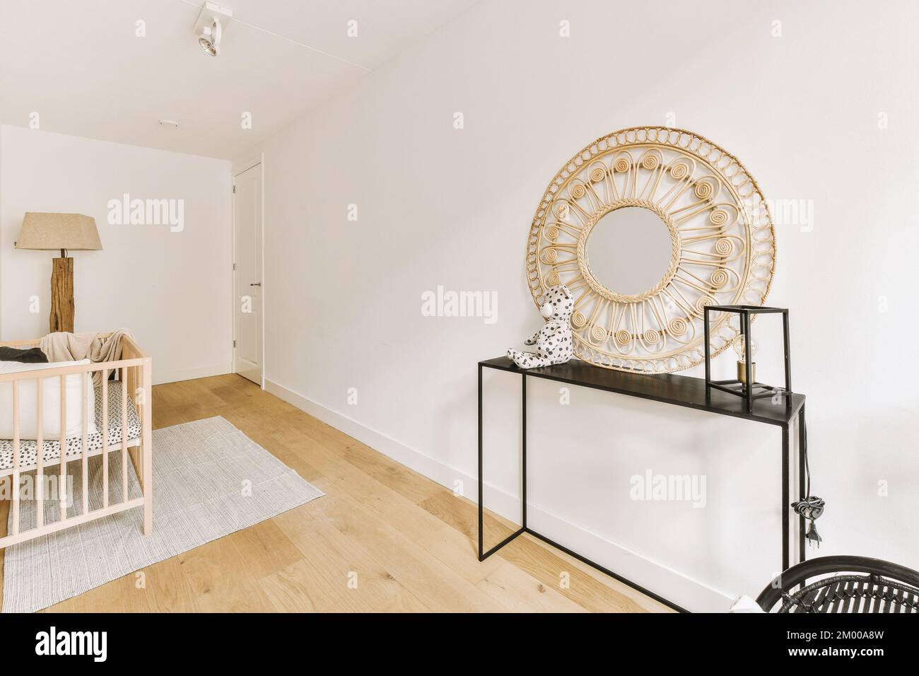 Interior of white room with baby crib and armchair near window with ...