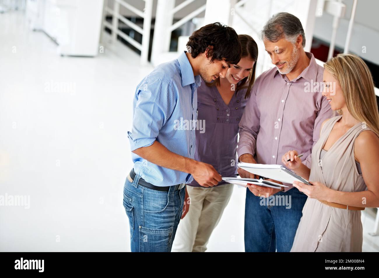 Comparing notes. A dynamic business team going over a brief together in ...
