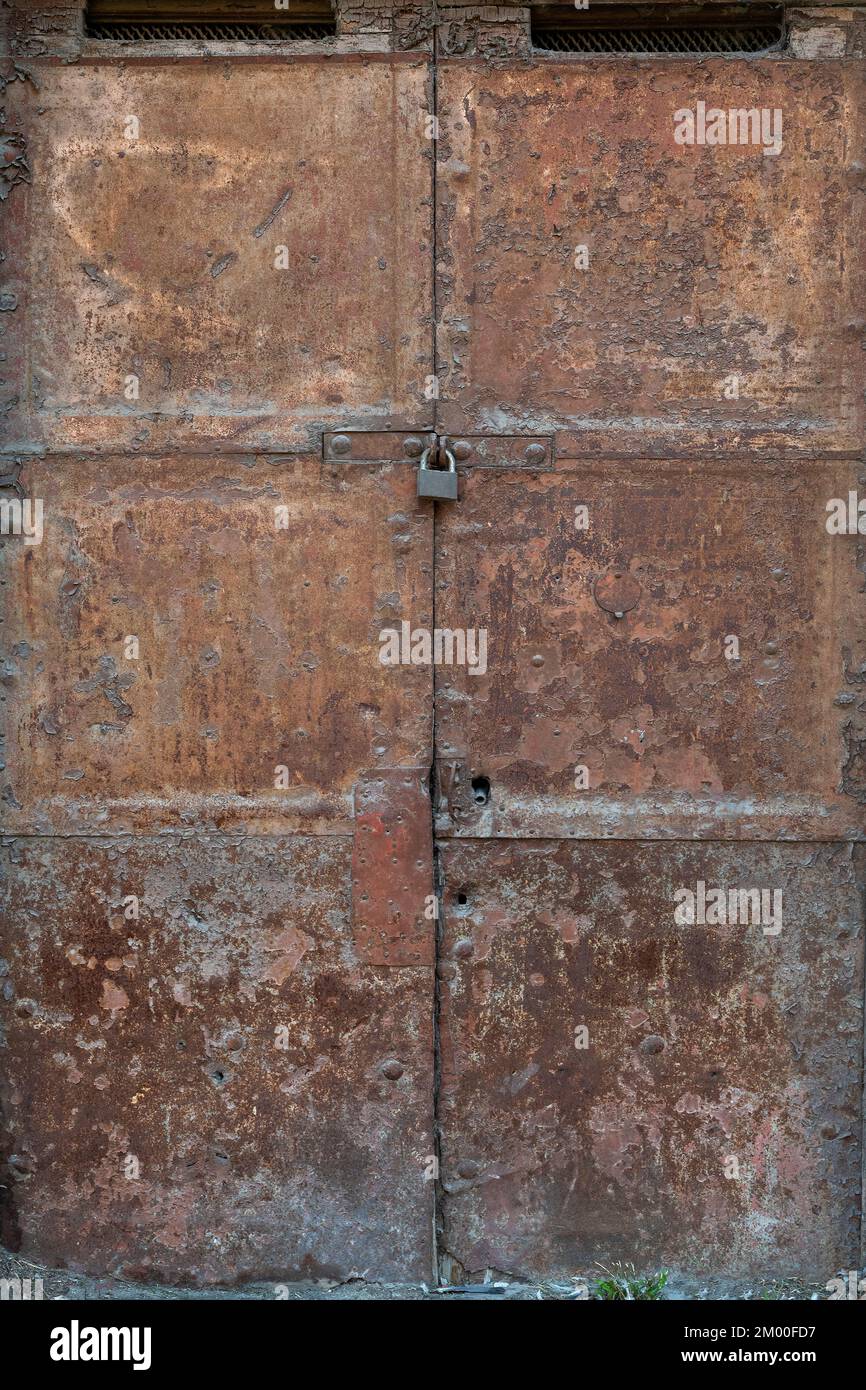 Ancient rusty iron door closed by a padlock Stock Photo - Alamy