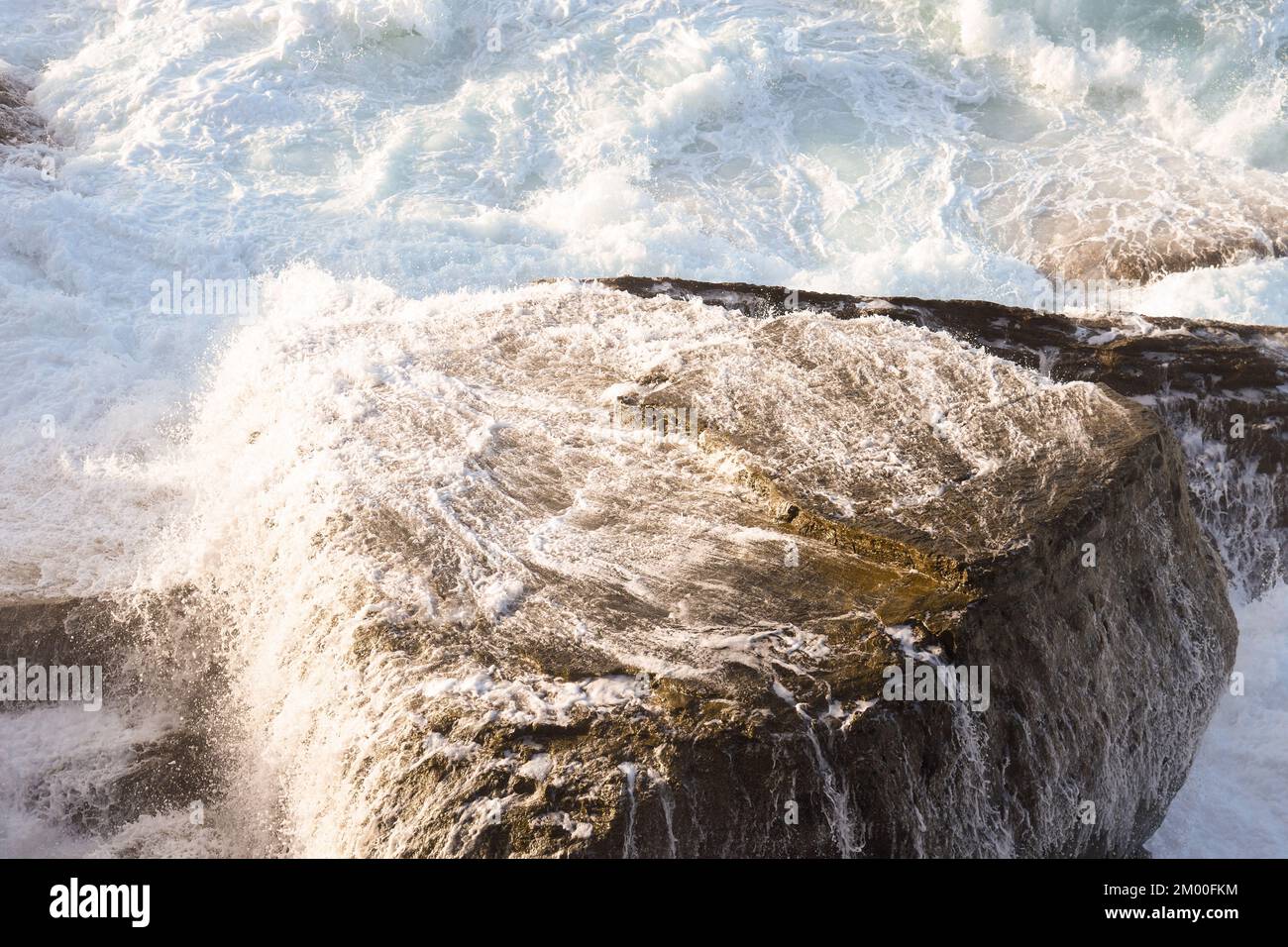 Water receding from a rock after the impact of a wave Stock Photo - Alamy