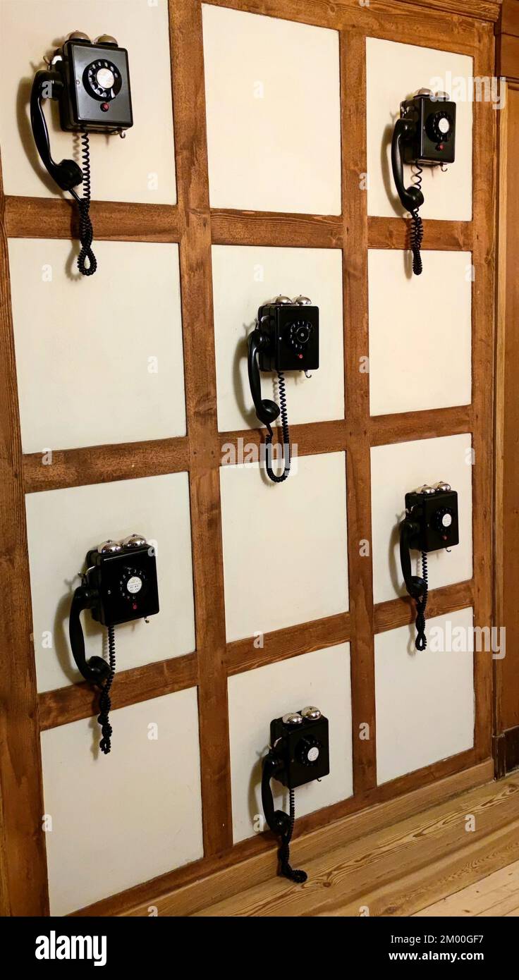 Funny sight of some antique analog phones on a wall Stock Photo - Alamy