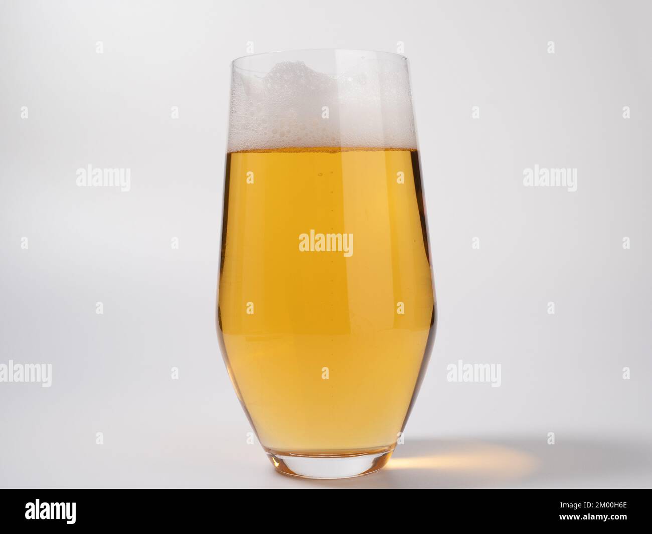 Glass of beer on a white background. A glass of light beer with foam ...