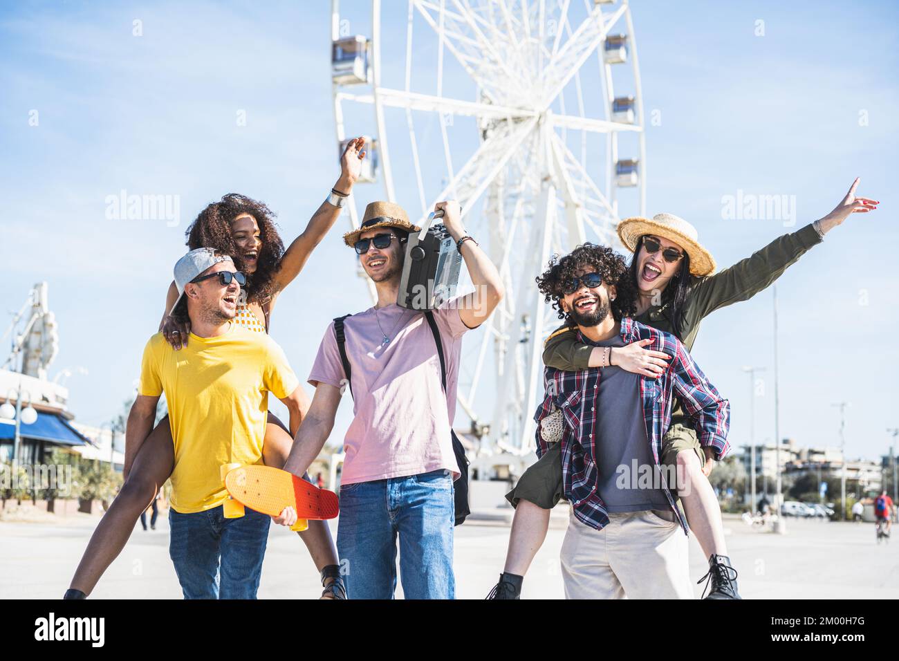 Multiracial group of friends going to the beach, having fun on holiday ...