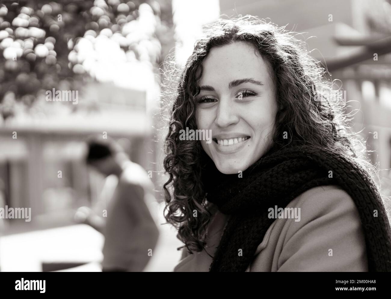 Happy girl with wavy hair laughing outdoor with urban city context as ...